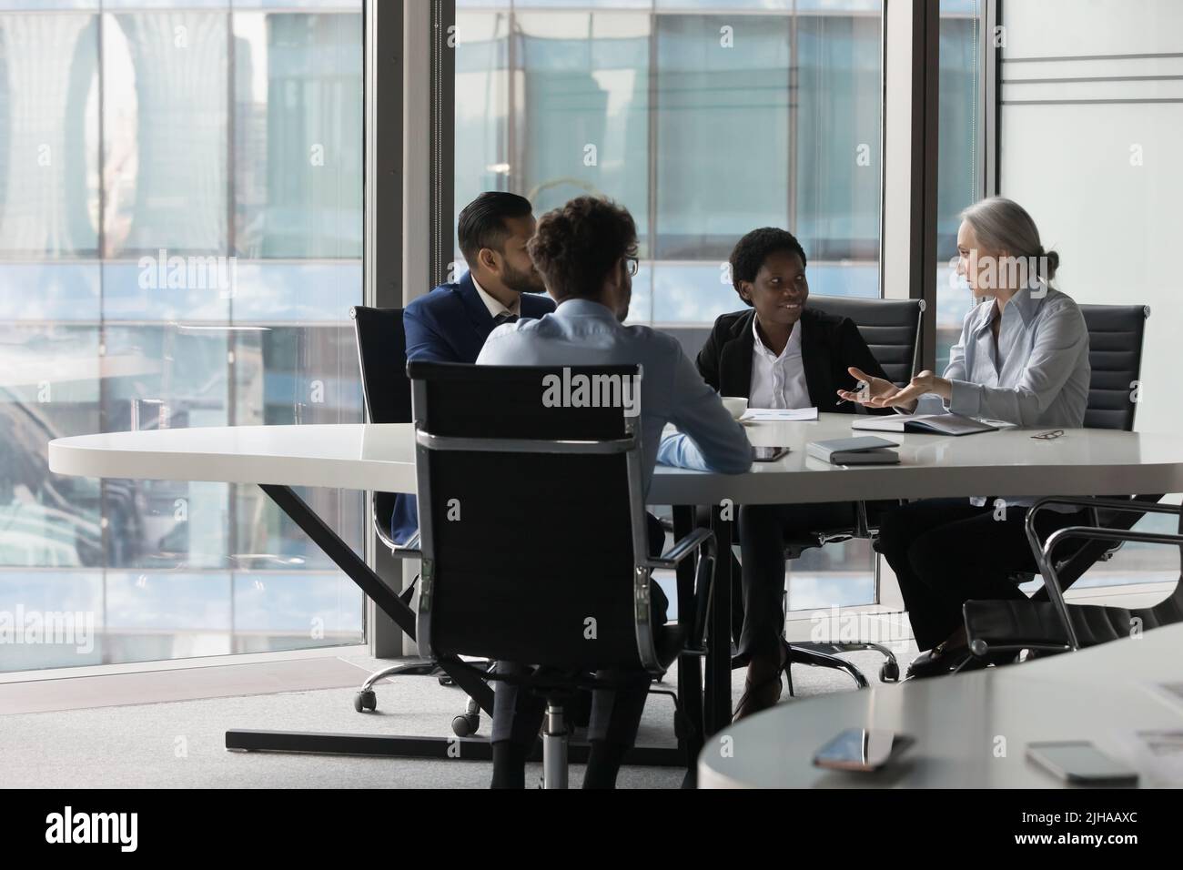 Mature business teacher, mentor training diverse team of interns Stock ...