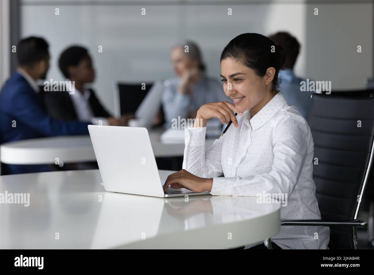 Happy pretty Indian employee girl working on successful online project ...