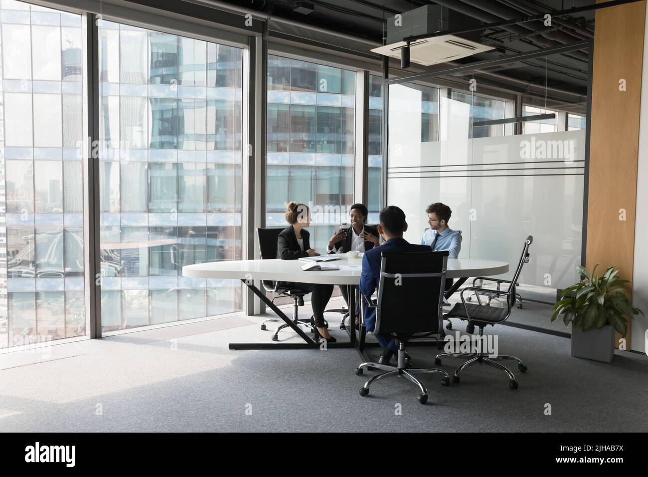 Diverse millennial business team talking in meeting room Stock Photo ...