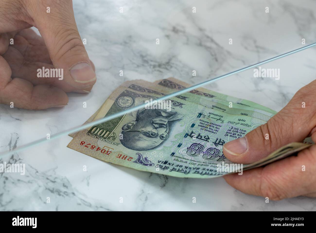 Indian money clip, 100 rupee banknotes, Passing through a bank window ...