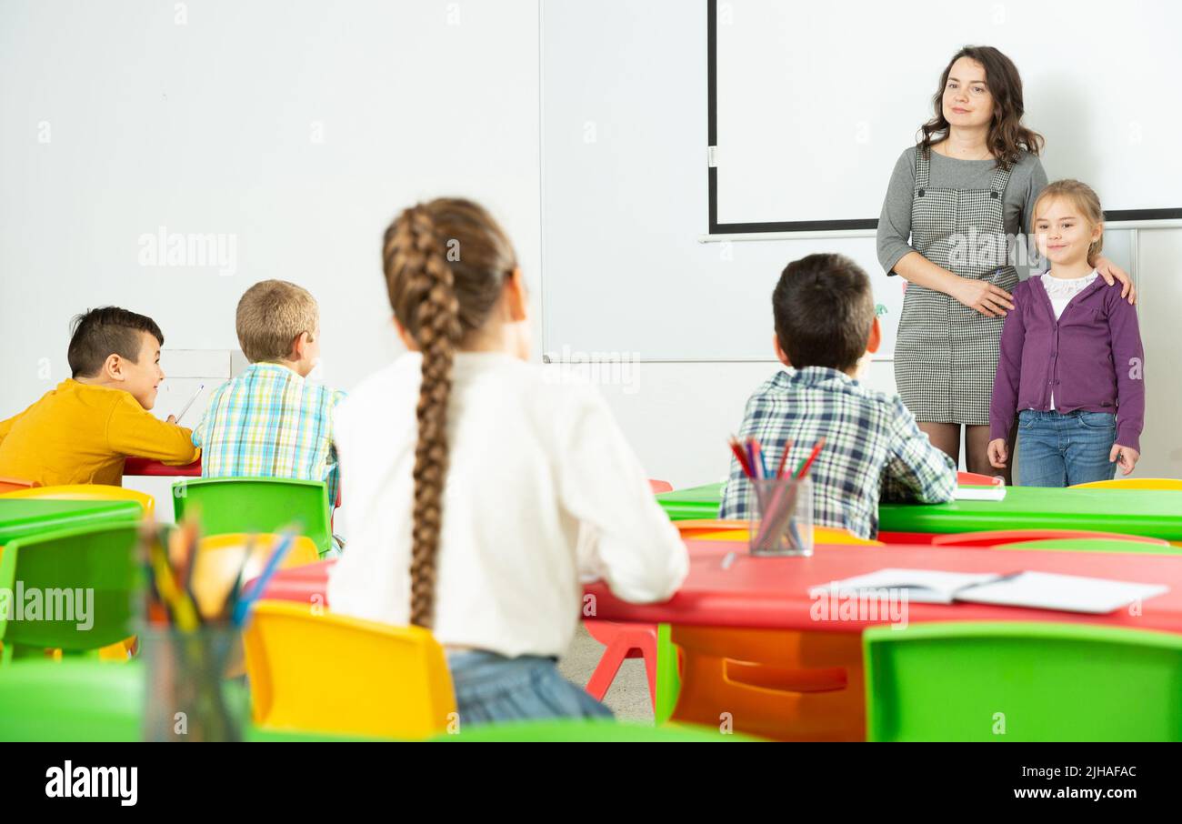 Teacher introducing new girl to class Stock Photo - Alamy