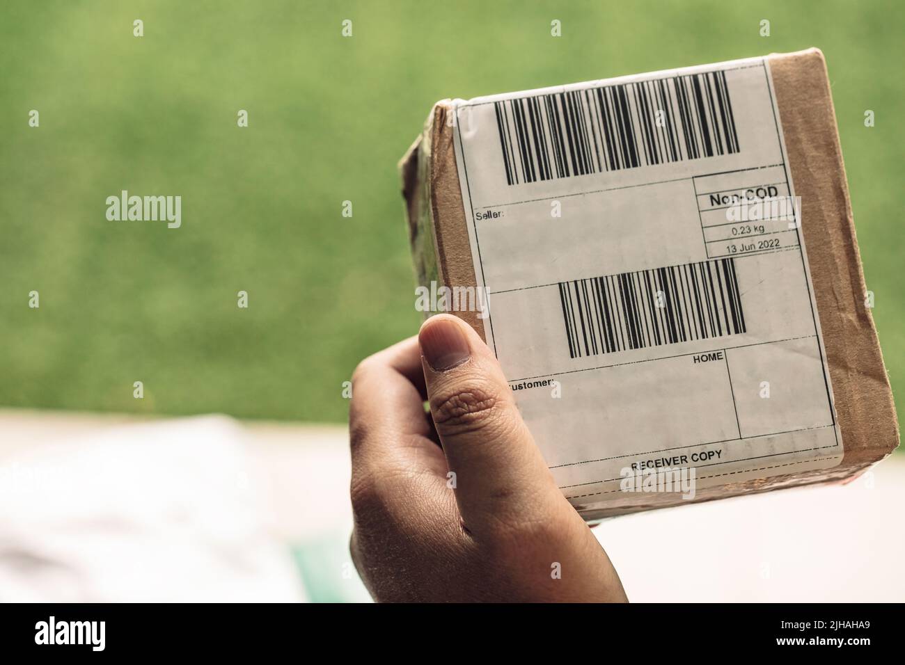 A young man holding small delivery package box Stock Photo - Alamy