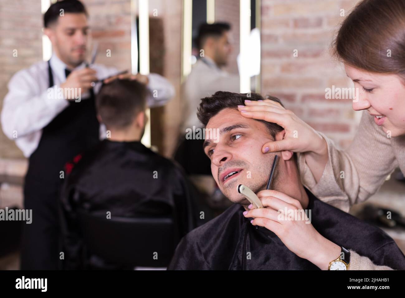 Male getting shave with straight razor in salon Stock Photo - Alamy