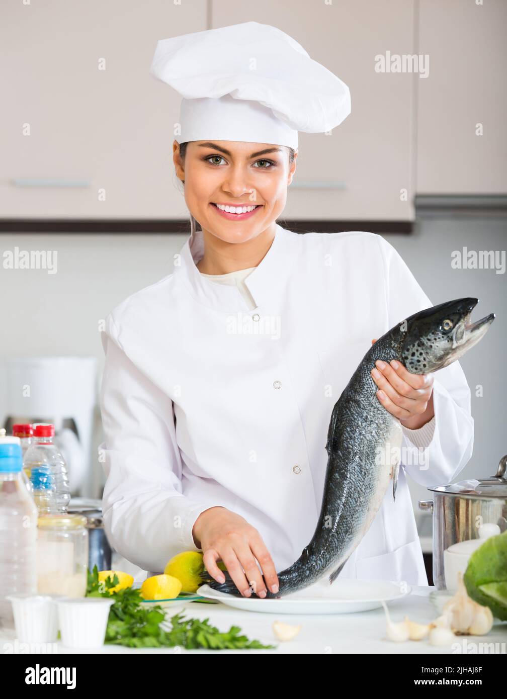 Female chef cooking fish Stock Photo - Alamy