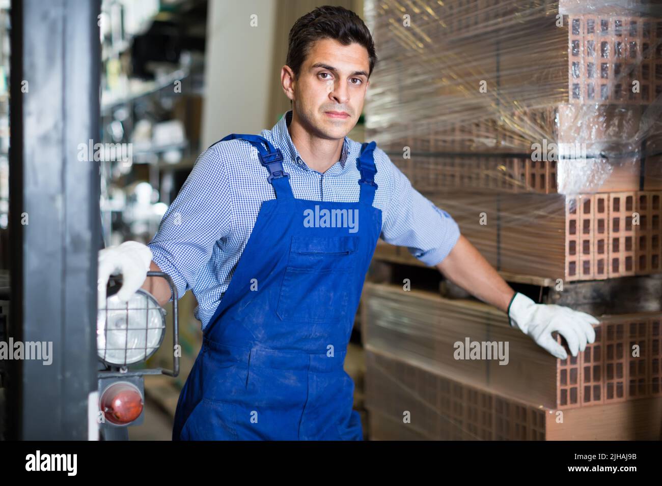 Portrait of active male in uniform on his workplace in building store ...