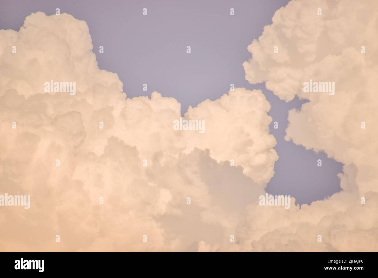 An aesthetic wallpaper with fluffy big clouds in the pink sky Stock Photo - Alamy