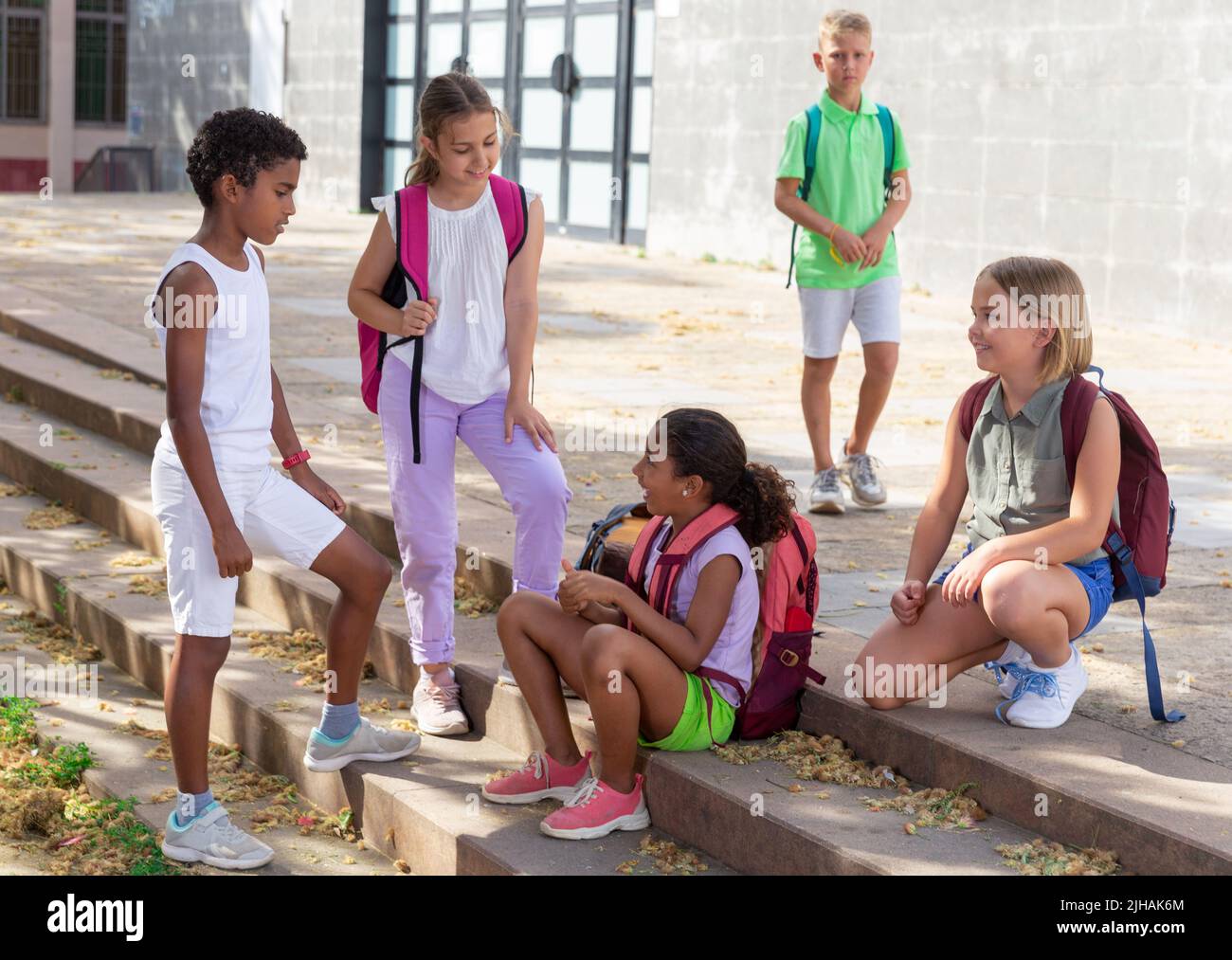 Group of kids sitting and standing on stairs Stock Photo - Alamy