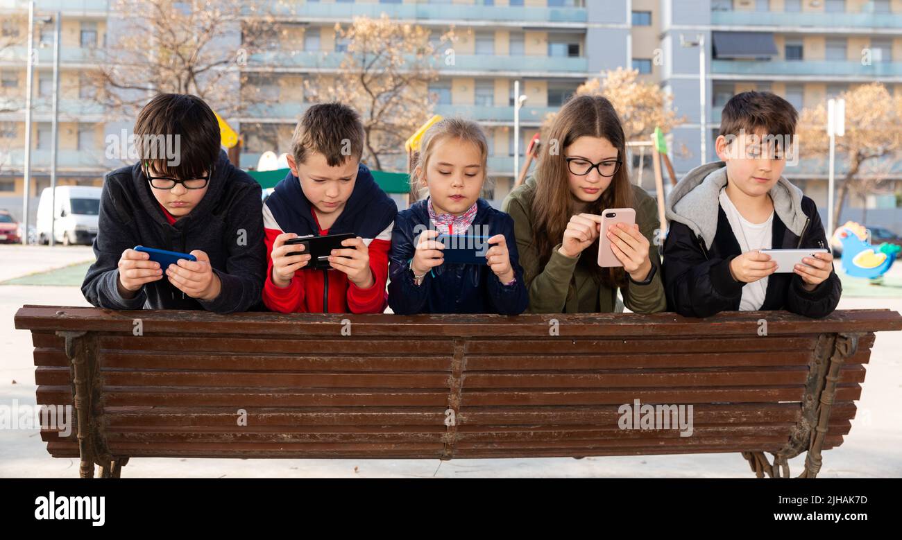 Children addicted in their phones outdoors Stock Photo - Alamy