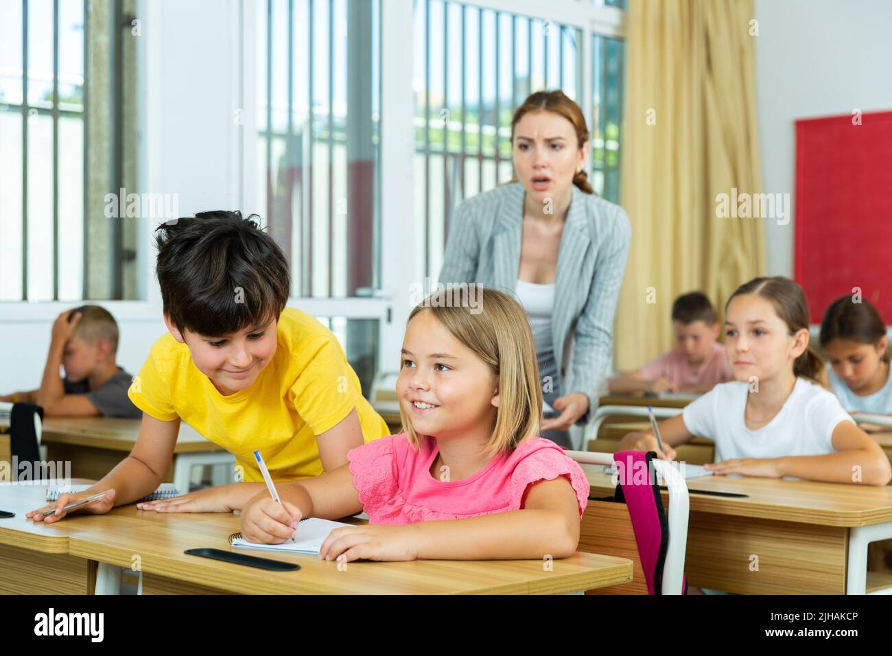Group of school kids and teacher during lesson in classroom Stock Photo ...