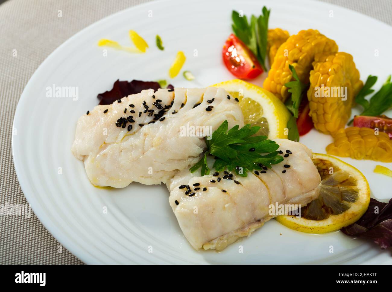 Hake steamed with corn, greens and lemon. Recipe Stock Photo - Alamy