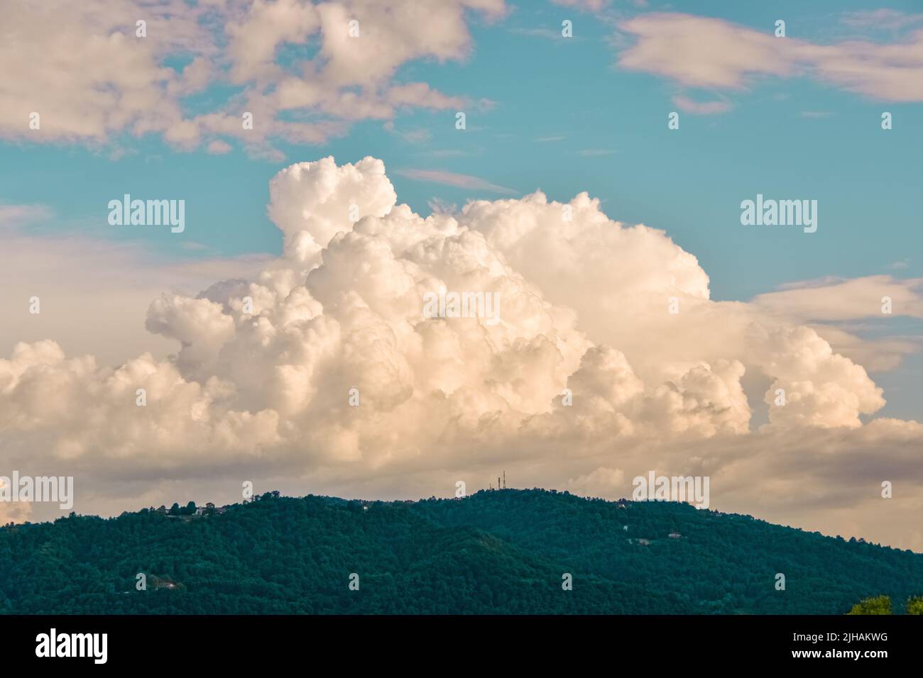 An aesthetic wallpaper with fluffy big clouds above the forested hill Stock Photo - Alamy