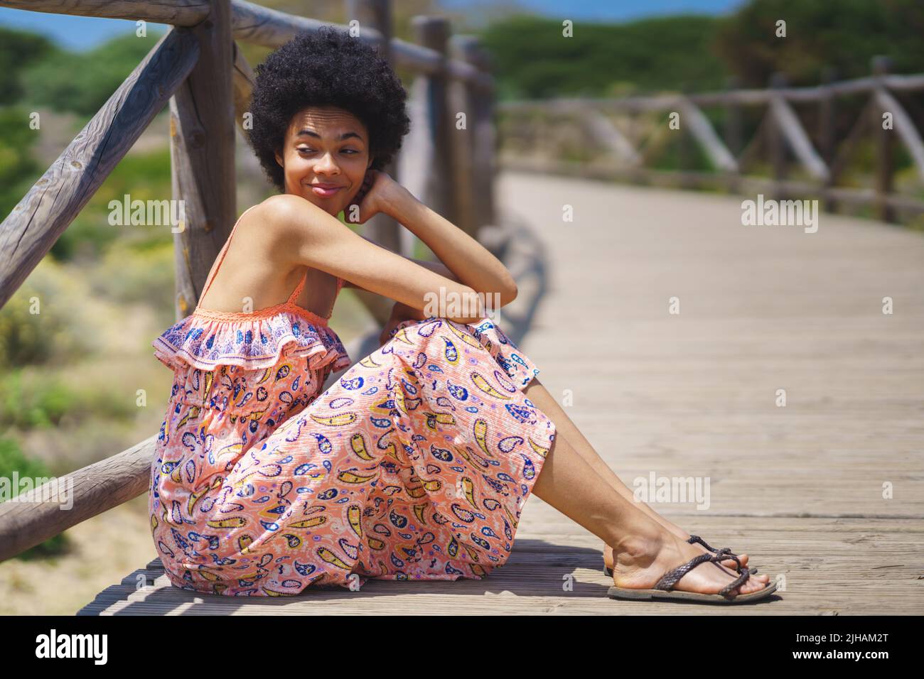 Positive ethnic female resting on lumber path Stock Photo - Alamy