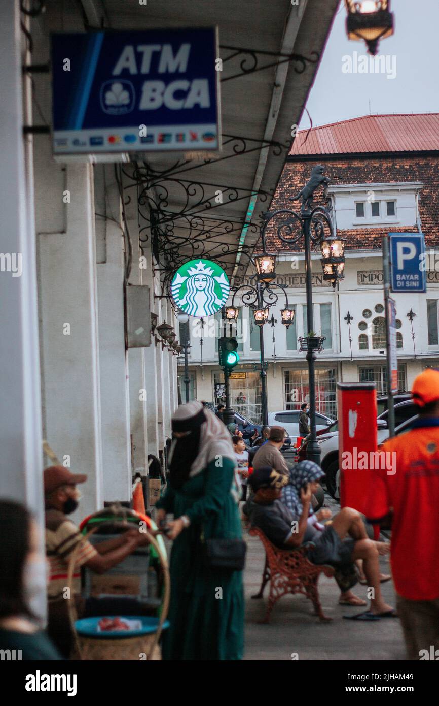 A vertical shot of a busy road with a Starbucks cafe in Bandung ...