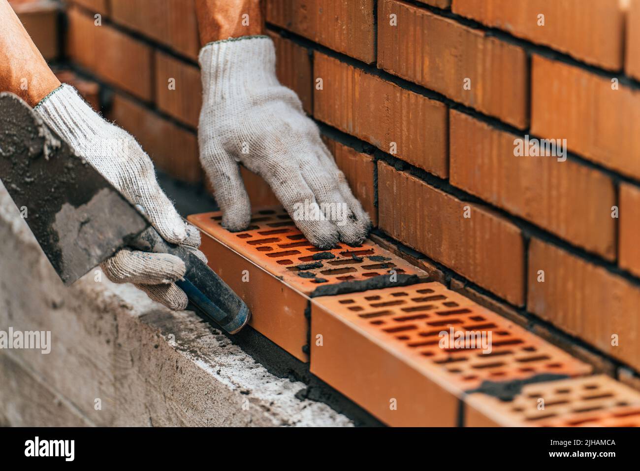 Worker or mason hands laying bricks close up. Bricklayer works at brick ...