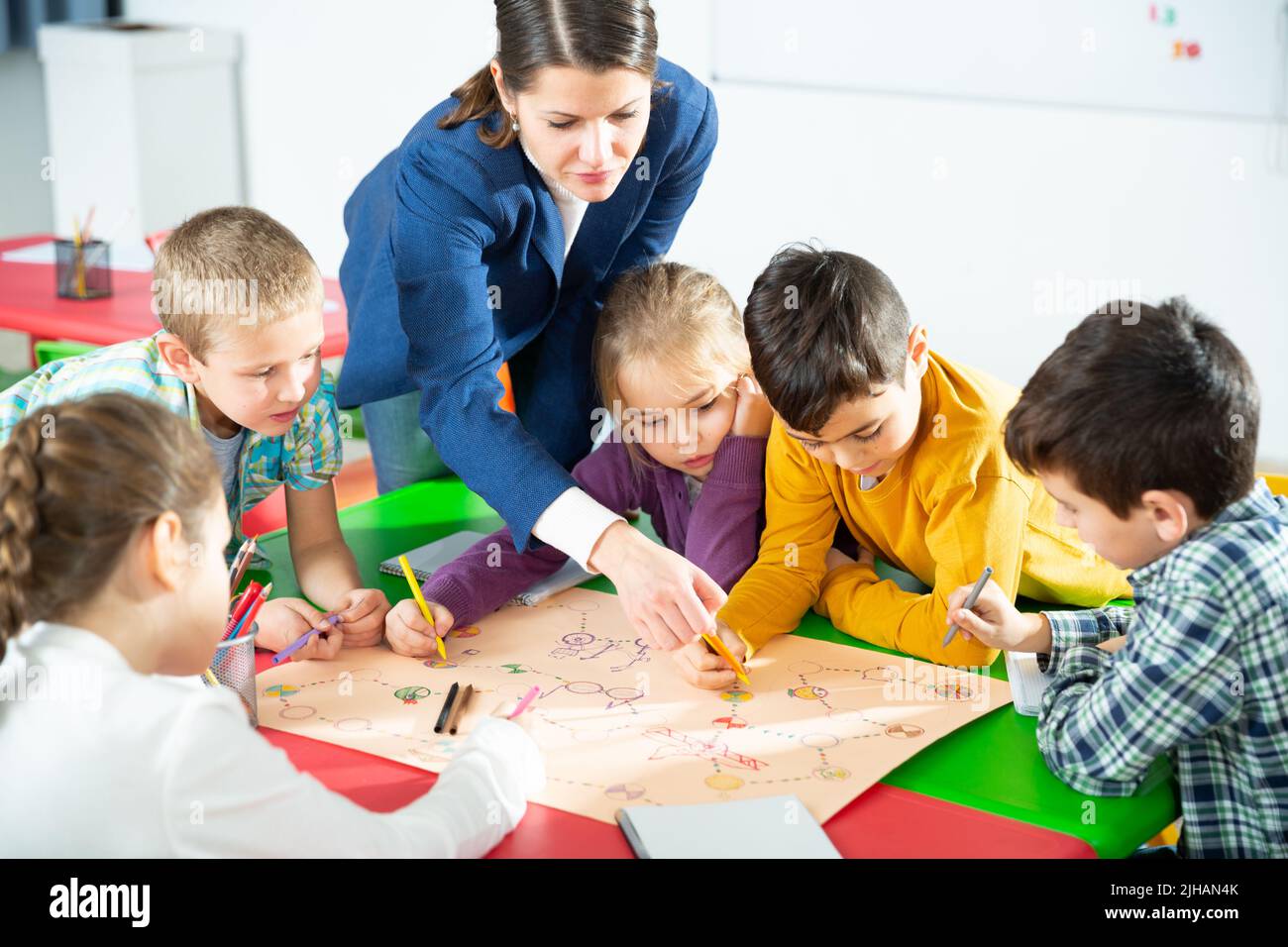 Kids with teacher playing educational tabletop game Stock Photo - Alamy