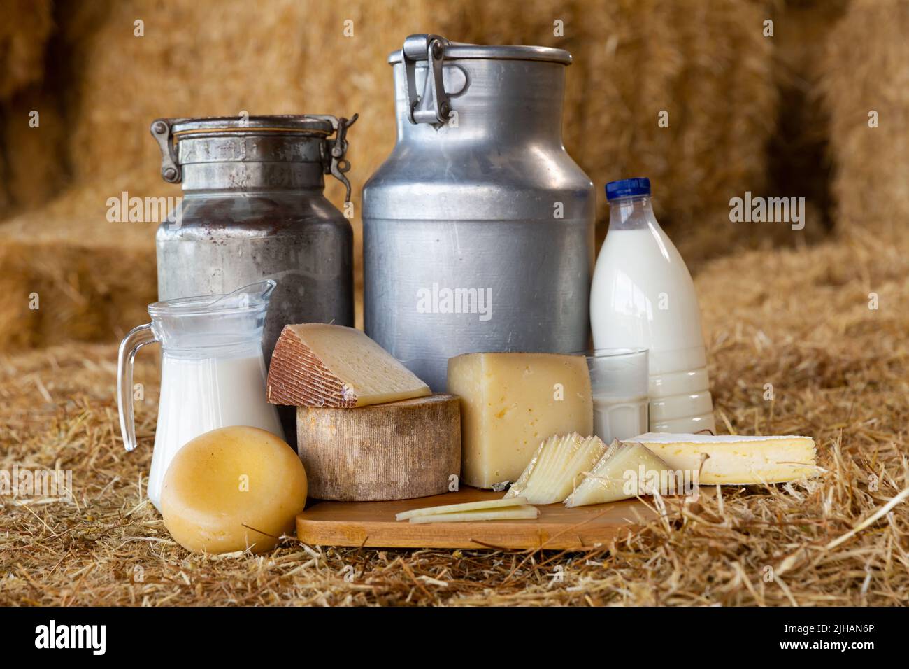 Composition of milk churns and wheels of cheeses Stock Photo - Alamy