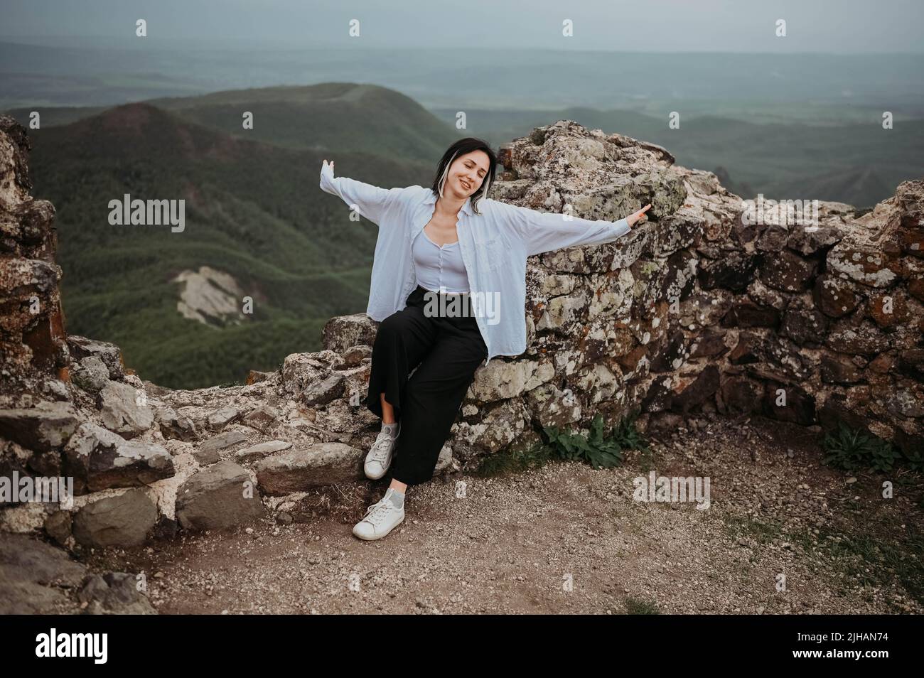 Happy woman tourist hiking up mountain enjoying nature. Landscape in ...