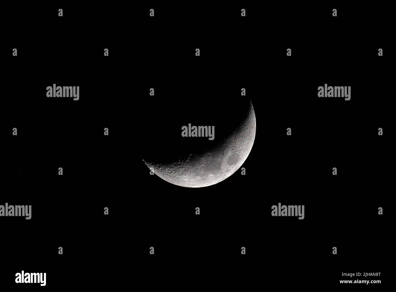 A crescent gray moon in a black night sky Stock Photo - Alamy