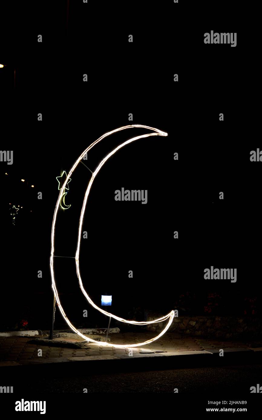A crescent made with led lights in the street as a festive sign ...