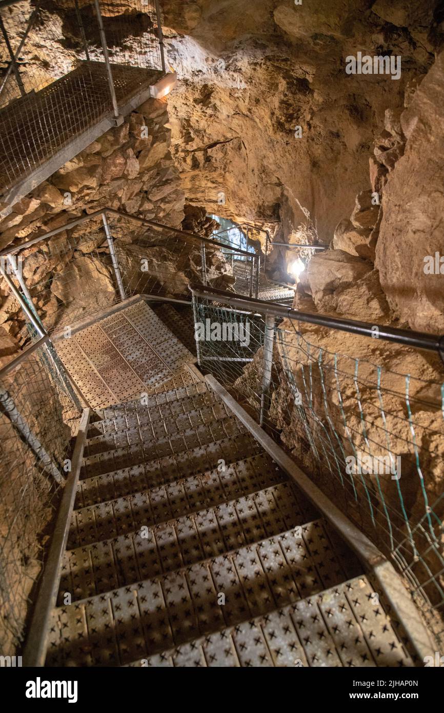 A vertical shot of metallic stairs to a cave Stock Photo - Alamy