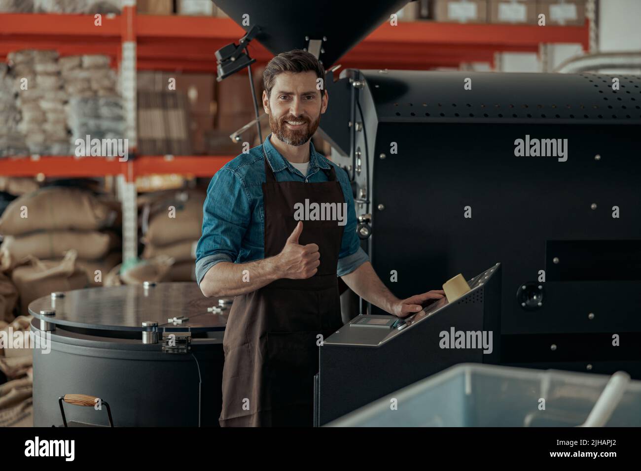 Worker operating of coffee roasted machine on small roasting factory ...