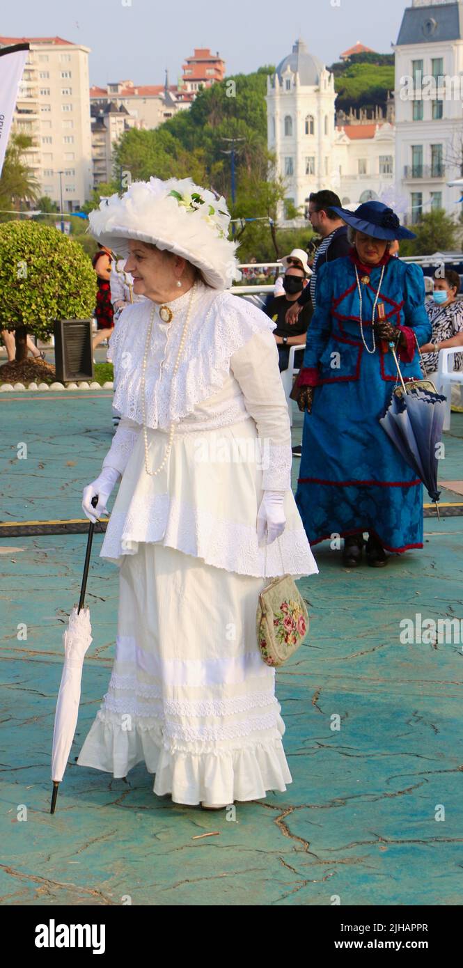 Women dressed in Victorian style dresses to celebrate the Bano de Olas ...