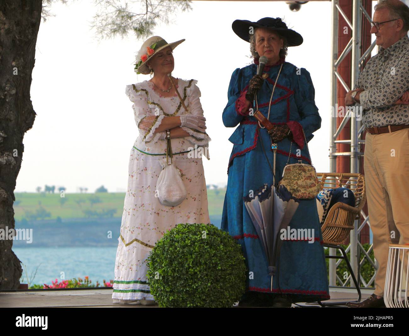 Women dressed in Victorian style dresses to celebrate the Bano de Olas ...
