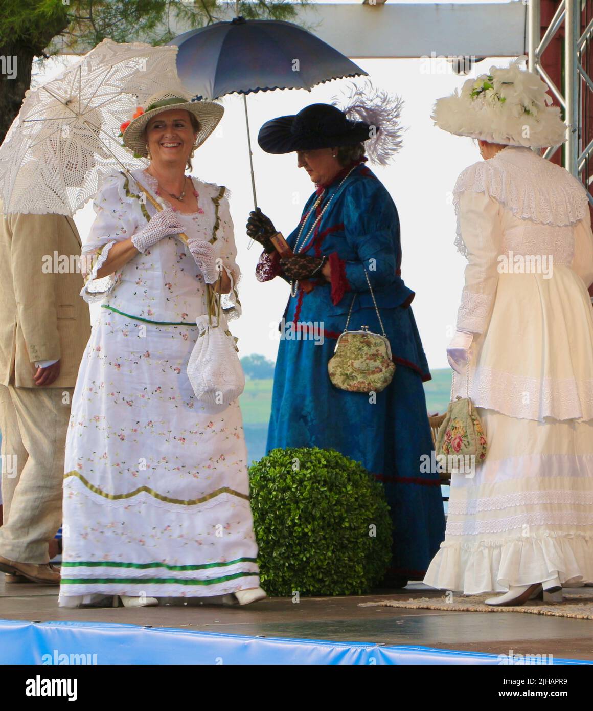 Women dressed in Victorian style dresses to celebrate the Bano de Olas ...