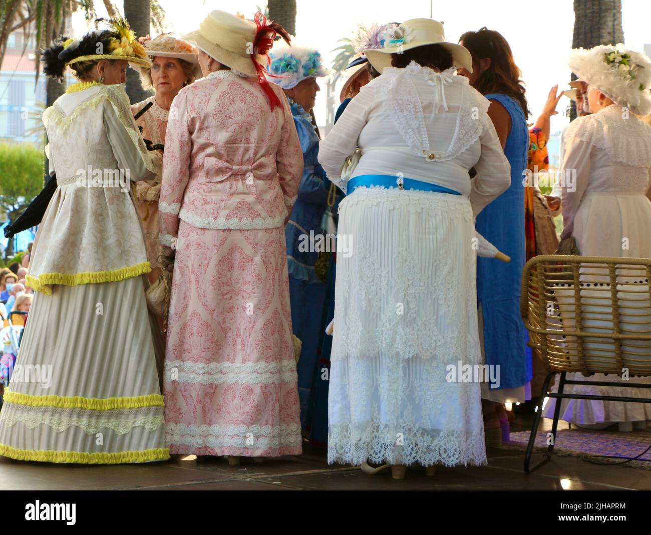 Women dressed in Victorian style dresses to celebrate the Bano de Olas ...