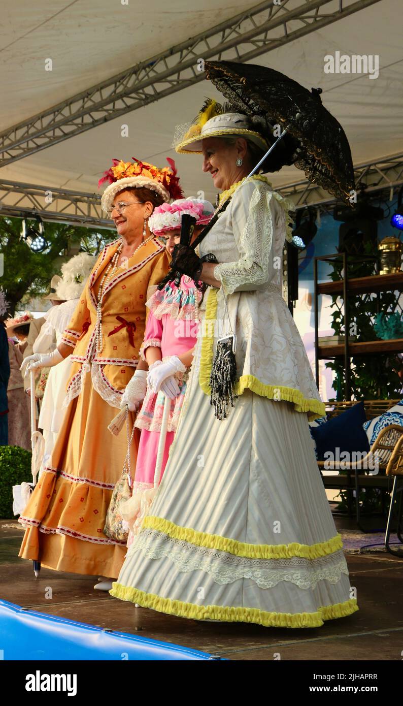 Women dressed in Victorian style dresses to celebrate the Bano de Olas ...