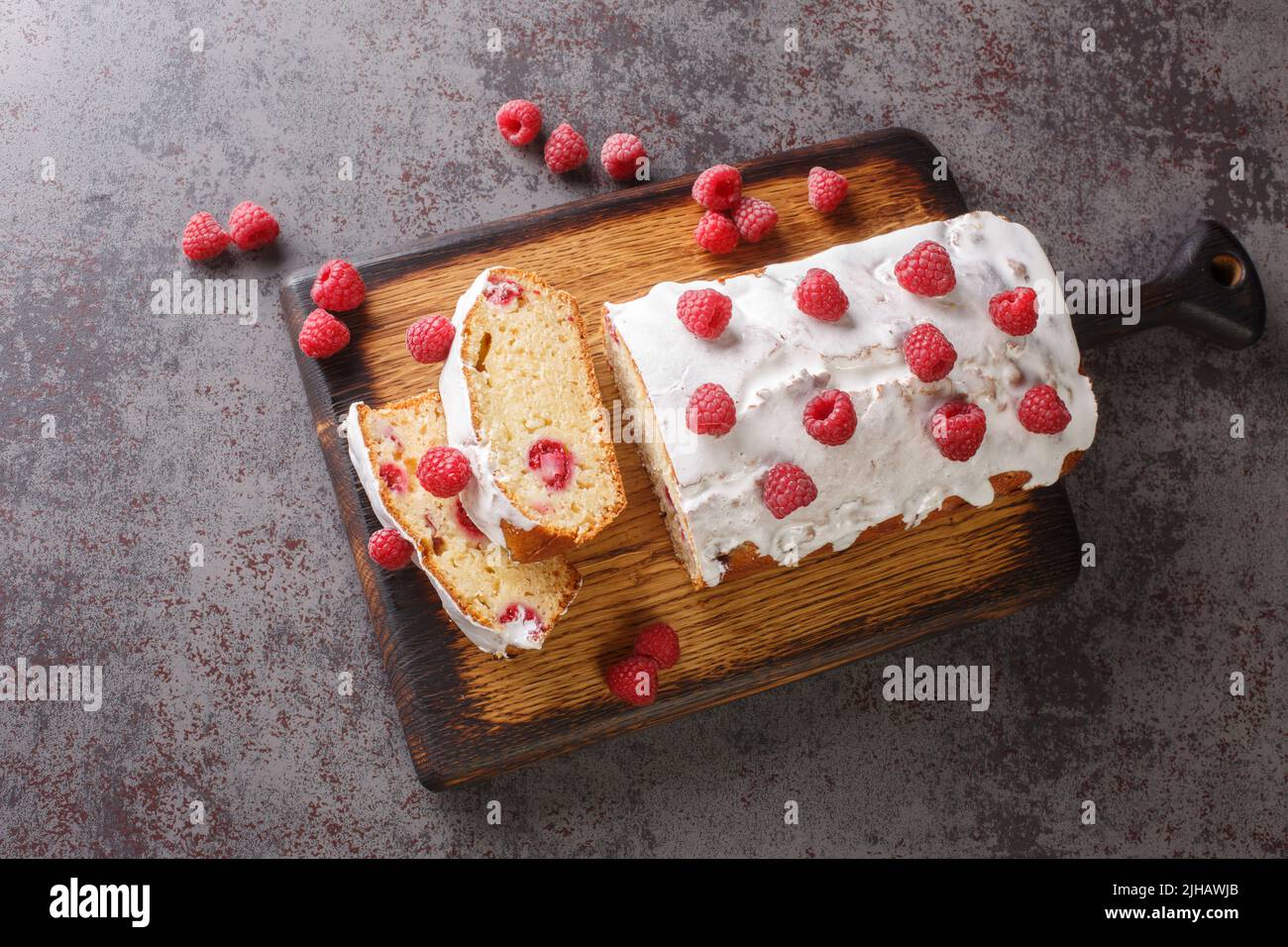 Vanilla cake with Raspberry and white lemon glaze close-up on a wooden ...