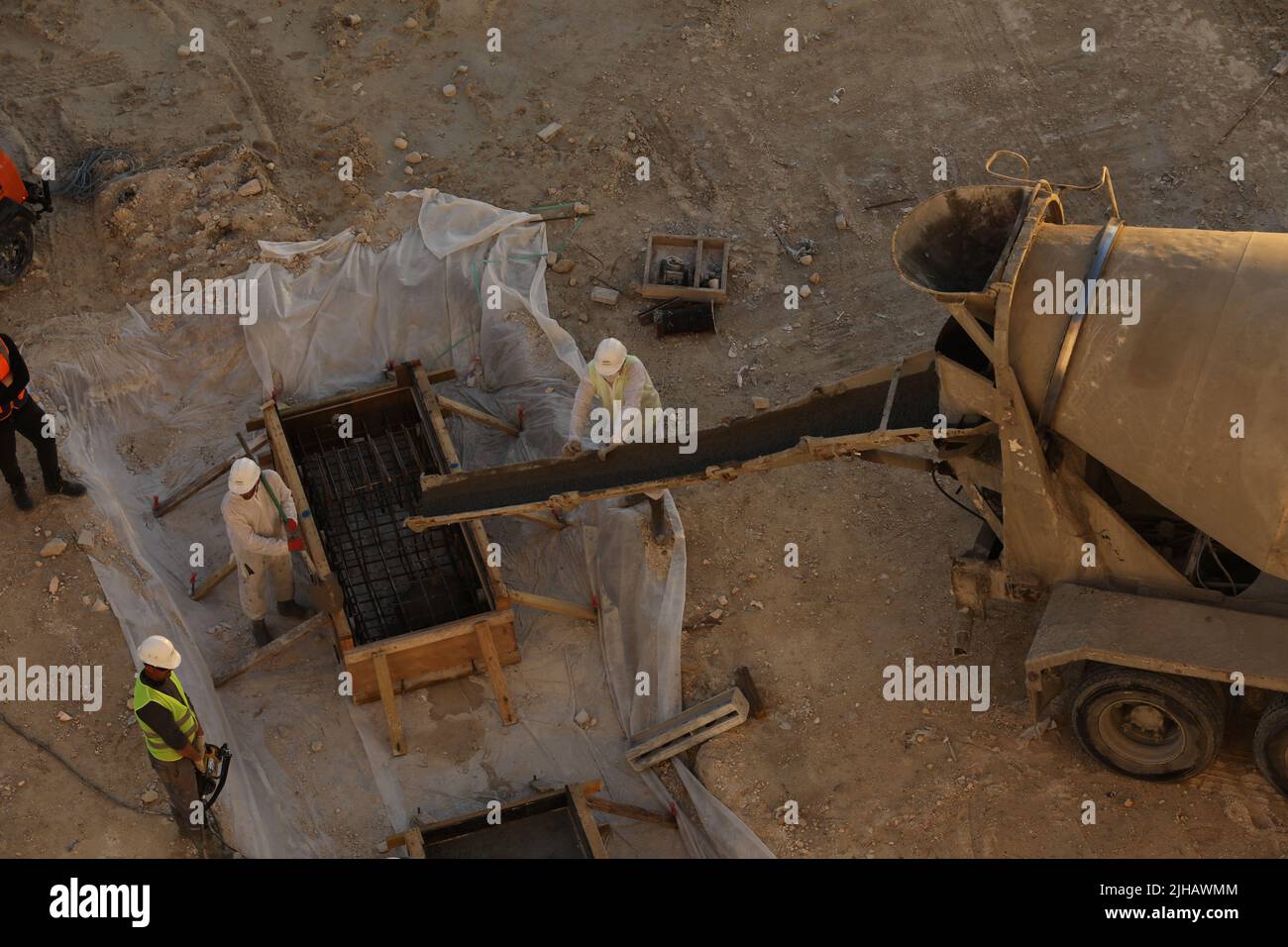 Concrete truck chute pouring wet cement Mix into metal bucket prepare ...