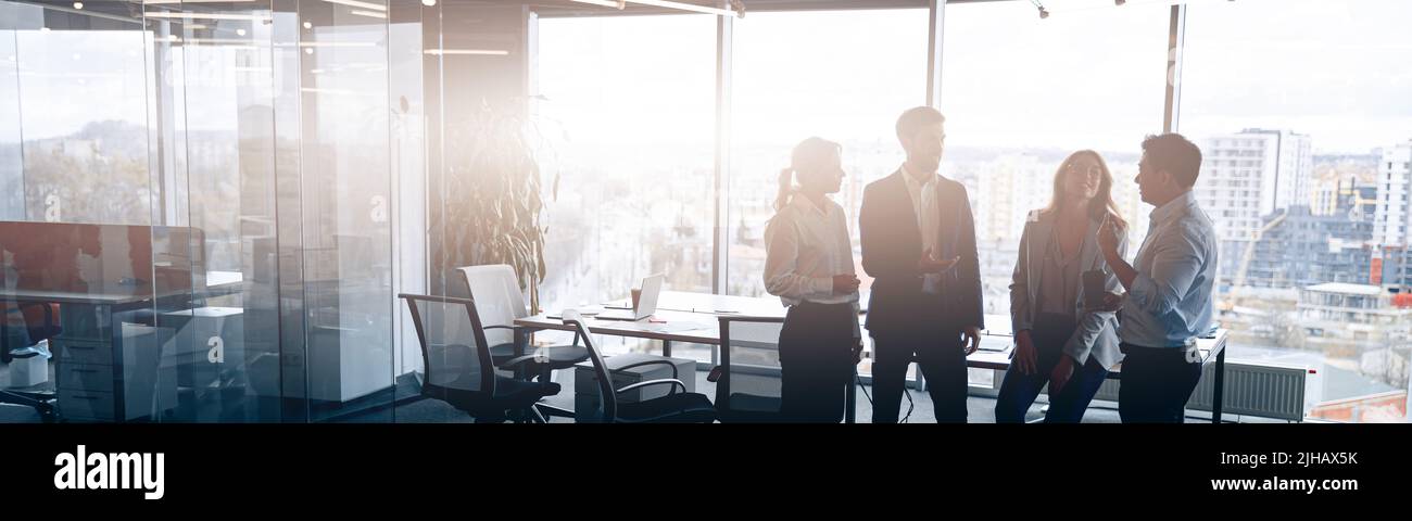 Business team standing against panoramic windows in modern office Stock ...