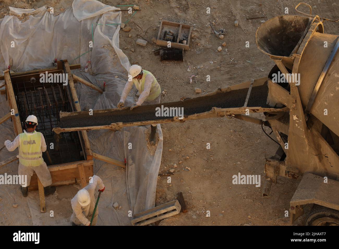 Concrete truck chute pouring wet cement Mix into metal bucket prepare ...