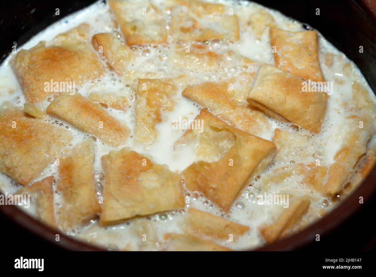 Milk on Egyptian bread pudding in a brown bowl pottery casserole made ...