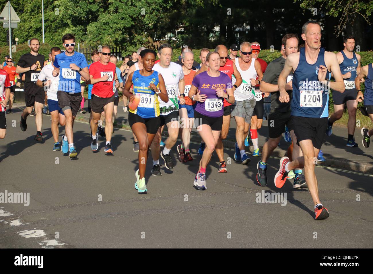 mixed group of runners in a road race Stock Photo - Alamy