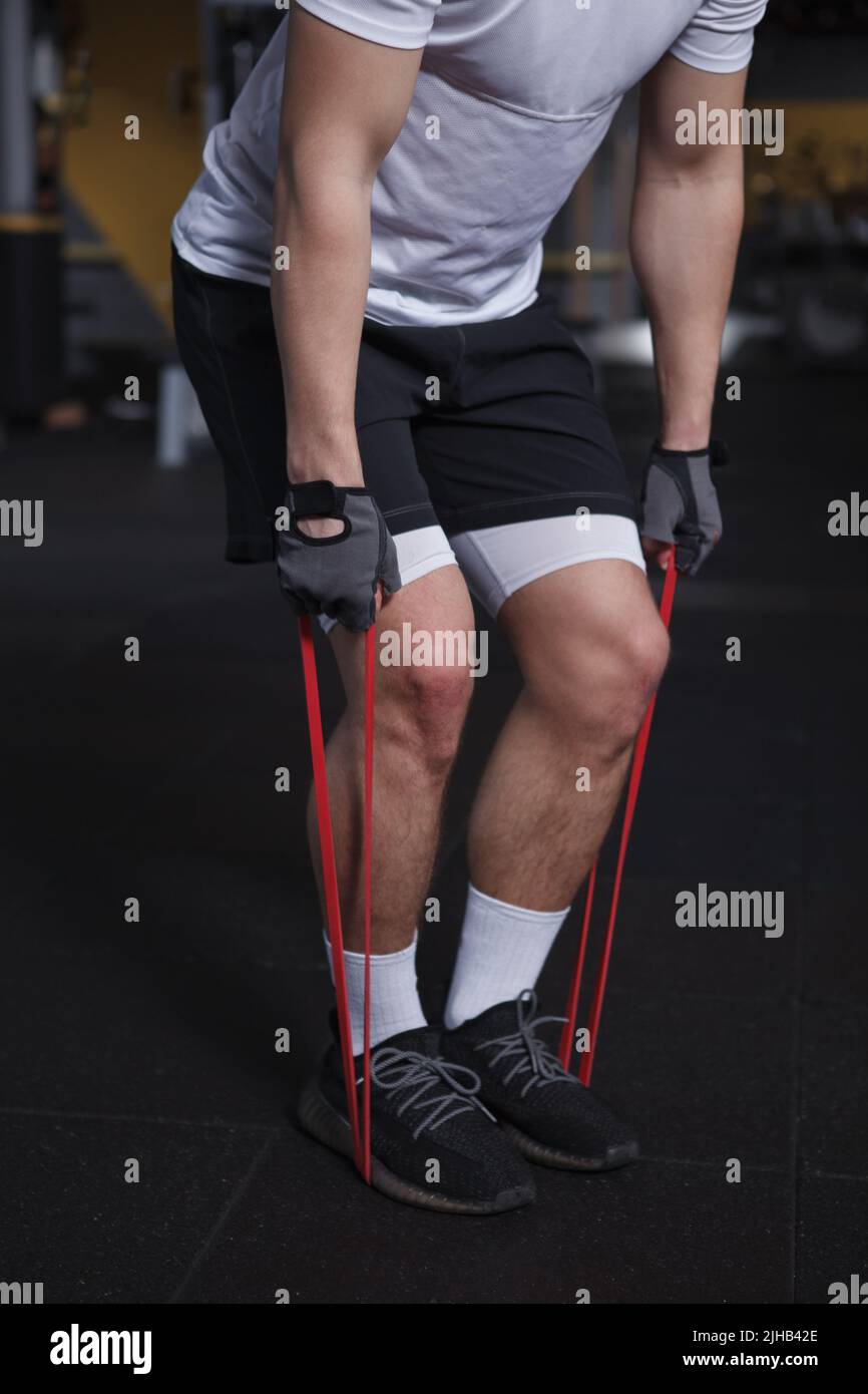 Vertical cropped shot of a sportsman doing resistance band workout ...