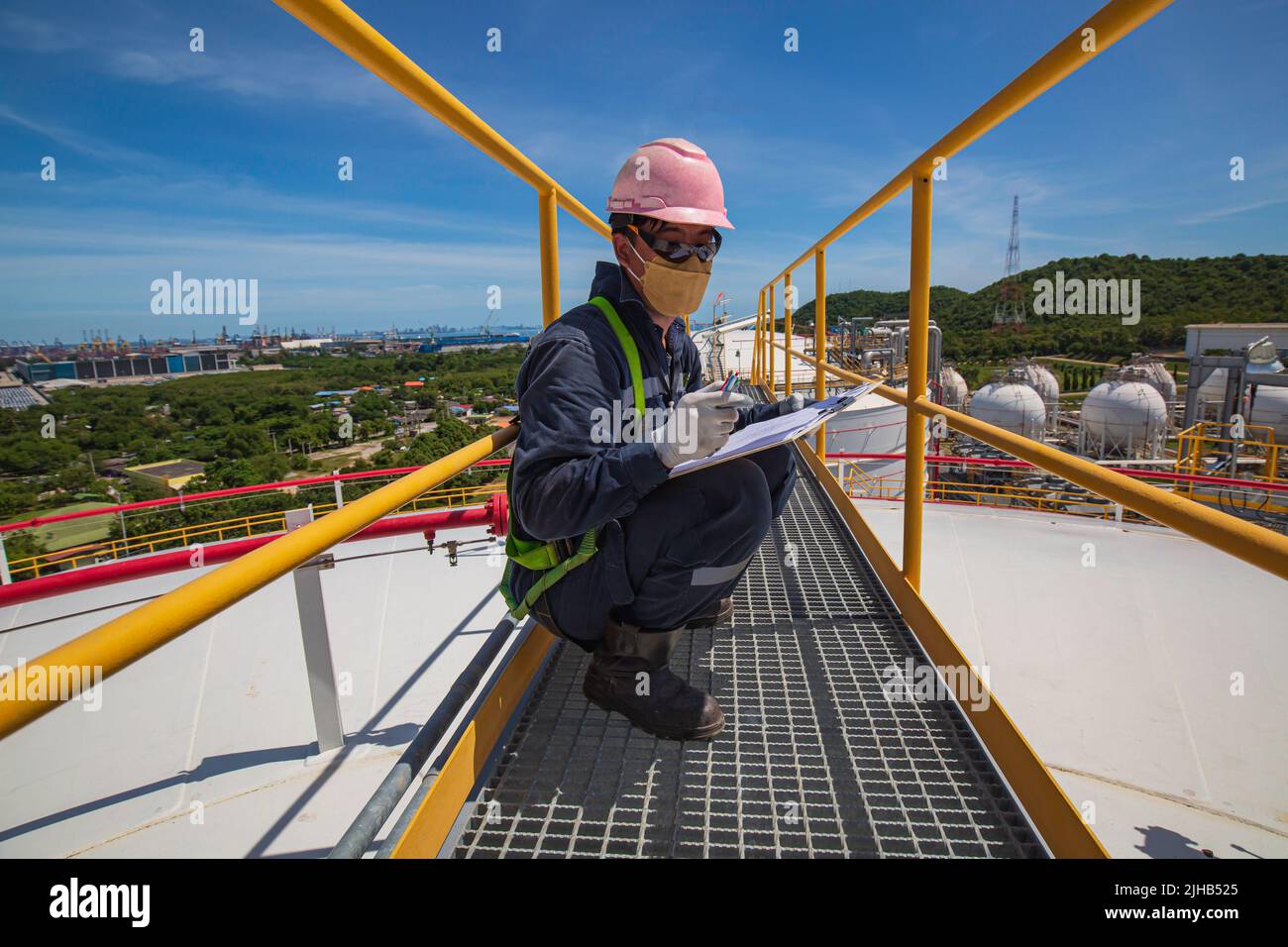 Male worker inspection visual roof storage tank oil background city and ...