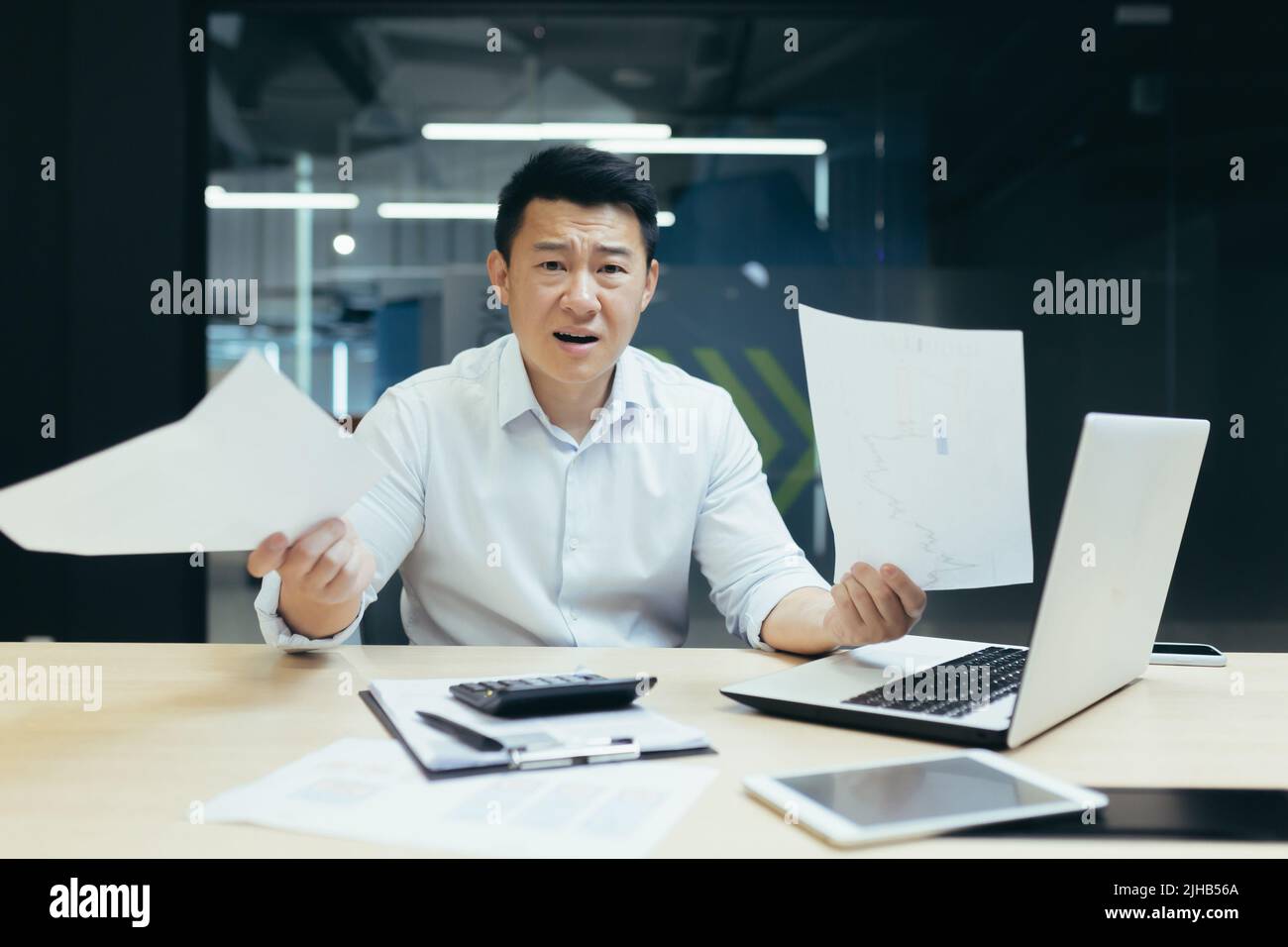 Portrait of a worried young businessman, accountant, financier. Sitting ...
