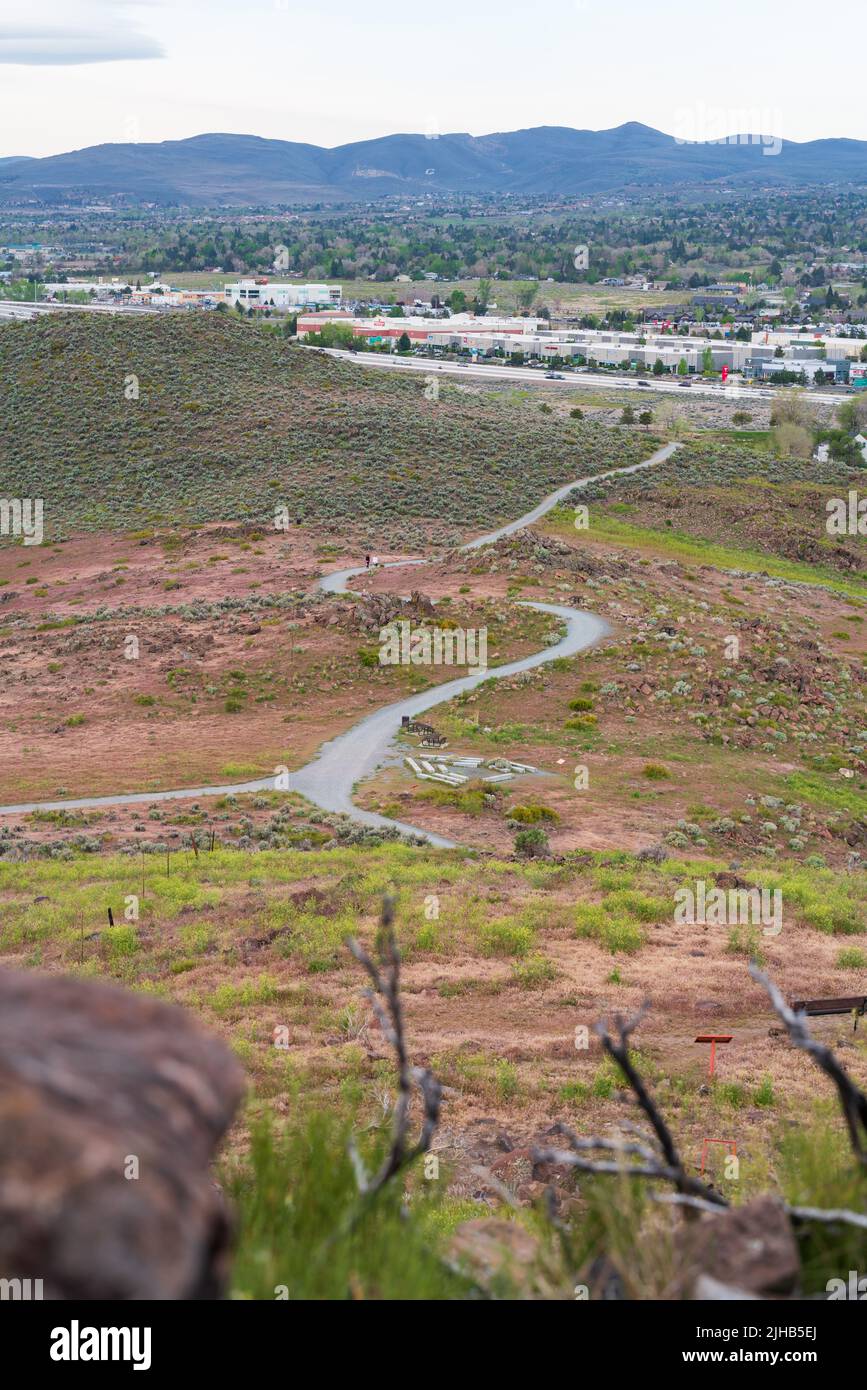 A vertical shot of a narrow road in the field with a background of ...