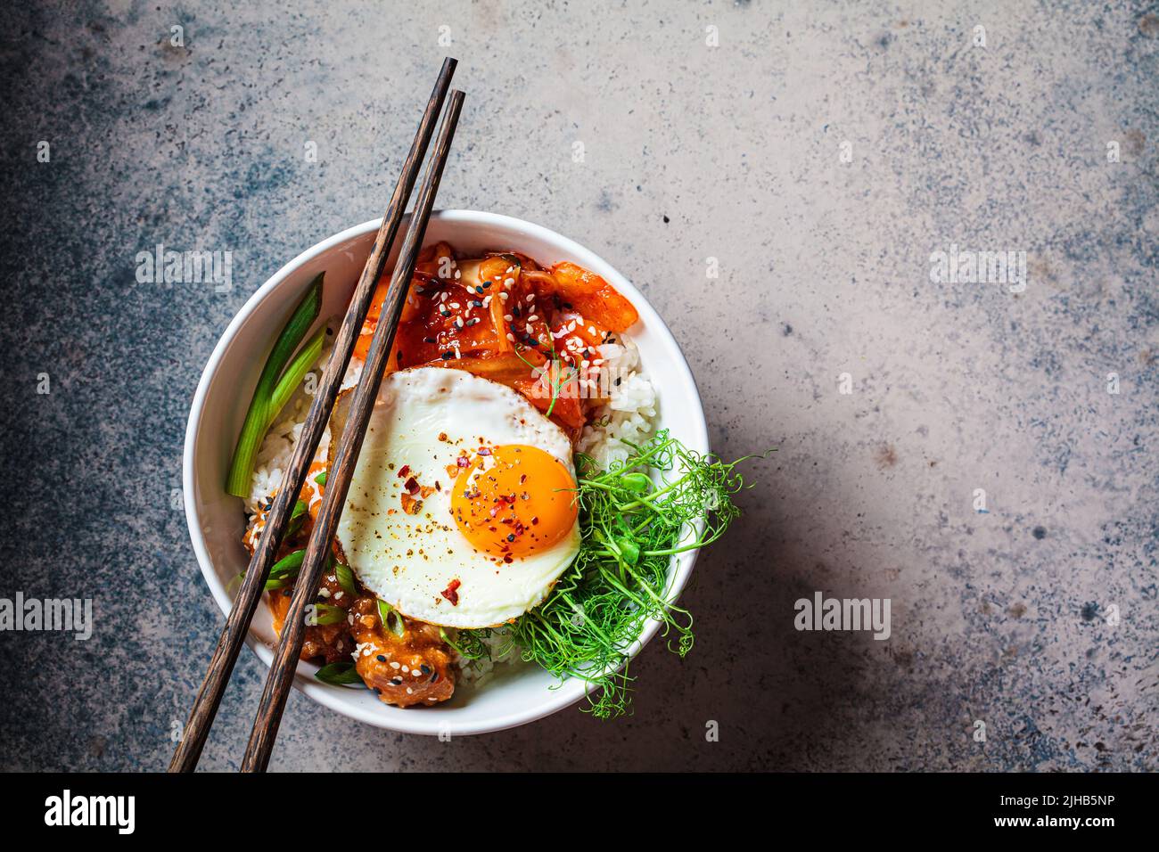 Bibimbap - meat, rice, kimchi, egg and sprouts in a white bowl, top ...