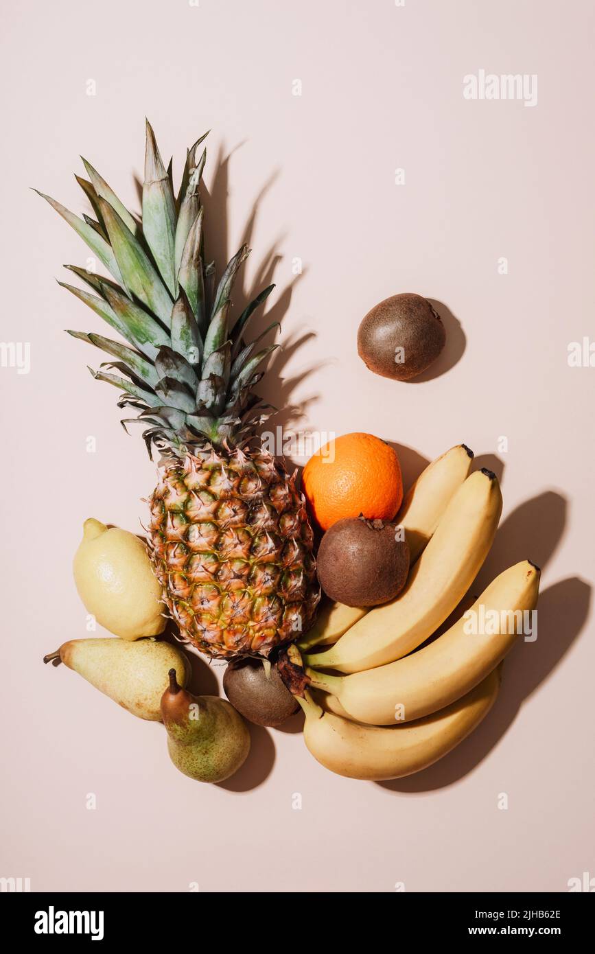 Tropical fruits on neutral background with sharp shadows. Top view ...