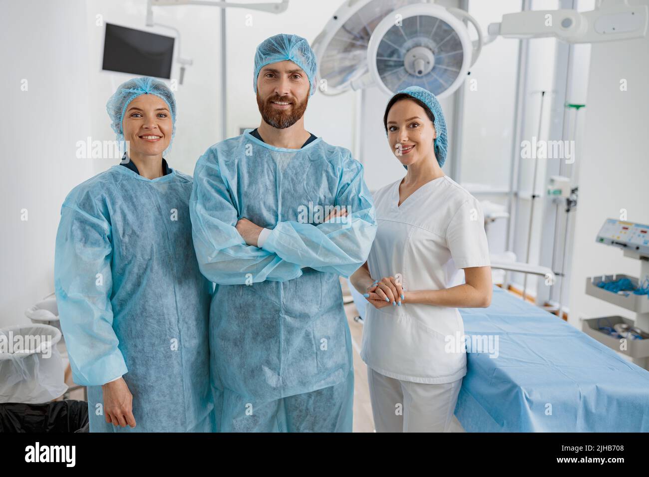 Team of professional surgeons and nurse standing in operating room ...