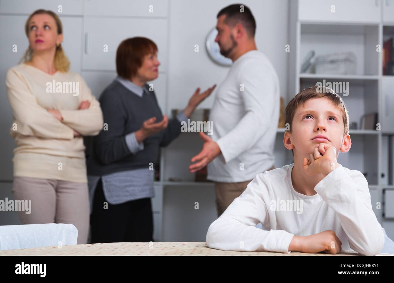 Unhappy boy during parents and grandma quarreling Stock Photo - Alamy