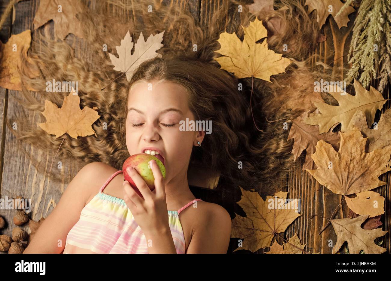 Munching an apple. Organic and natural food for kids health. Small girl ...
