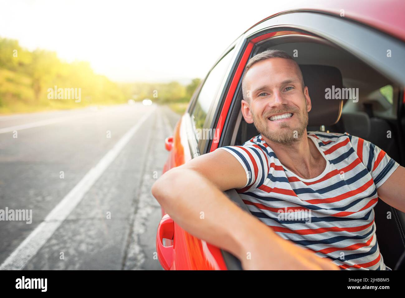 A man with a smile on his face drives a car Stock Photo - Alamy
