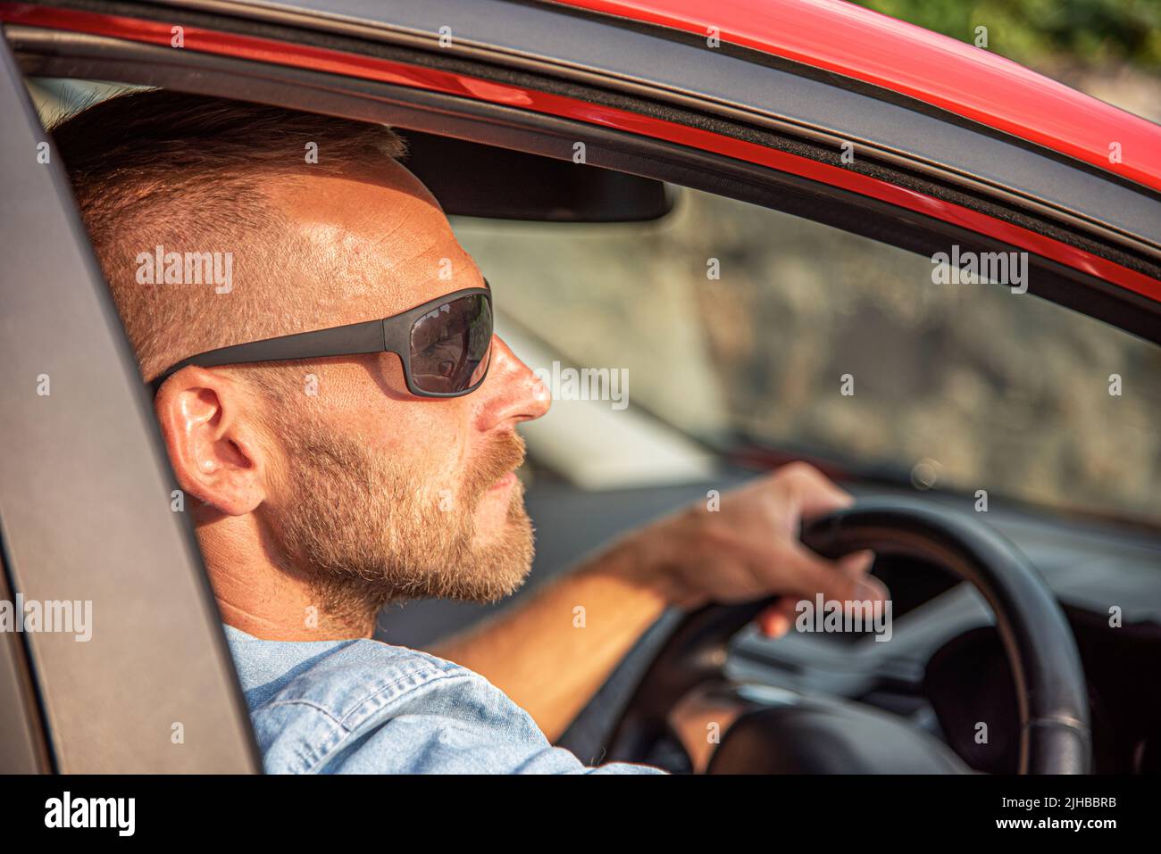 A man with a smile on his face drives a car Stock Photo - Alamy