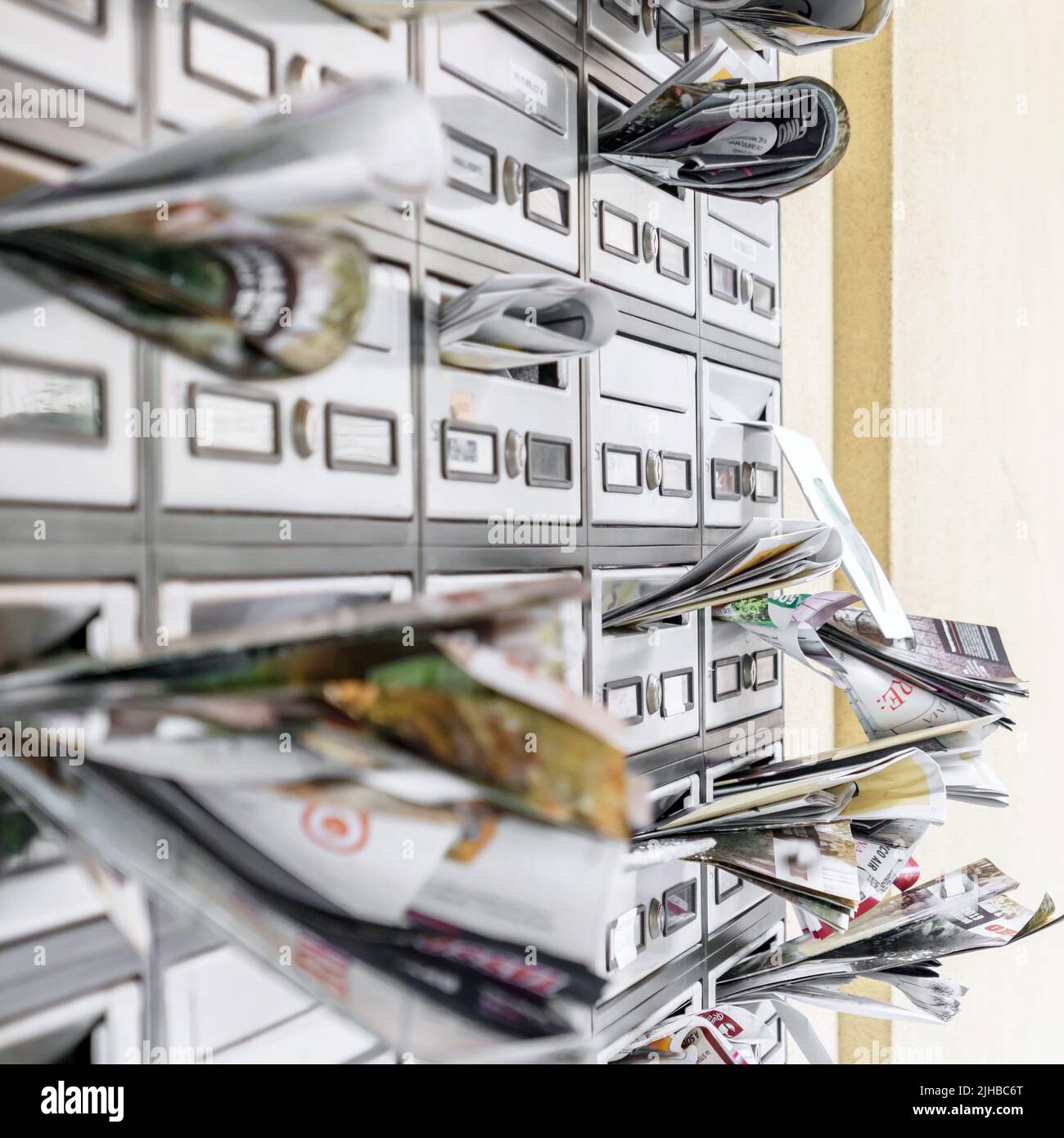 Mail boxes filled of leaflets. Many advertising leaflets are hanging ...