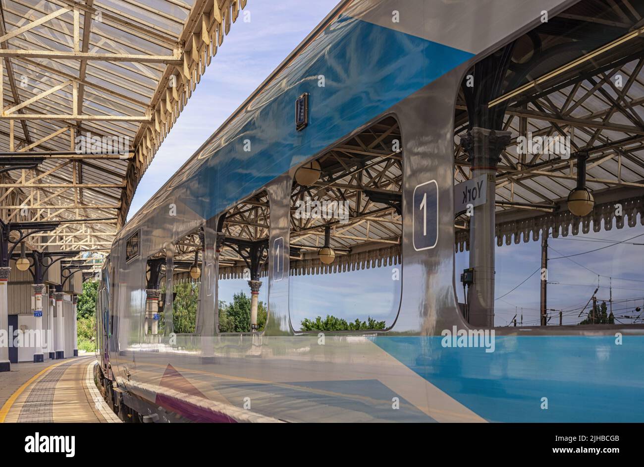 A close-up of railway carriages resting beneath a historic canopy. The ...