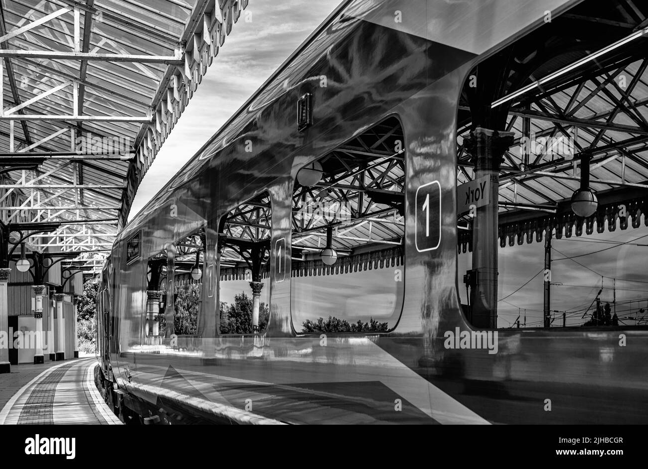 A close-up of railway carriages resting beneath a historic canopy. The ...
